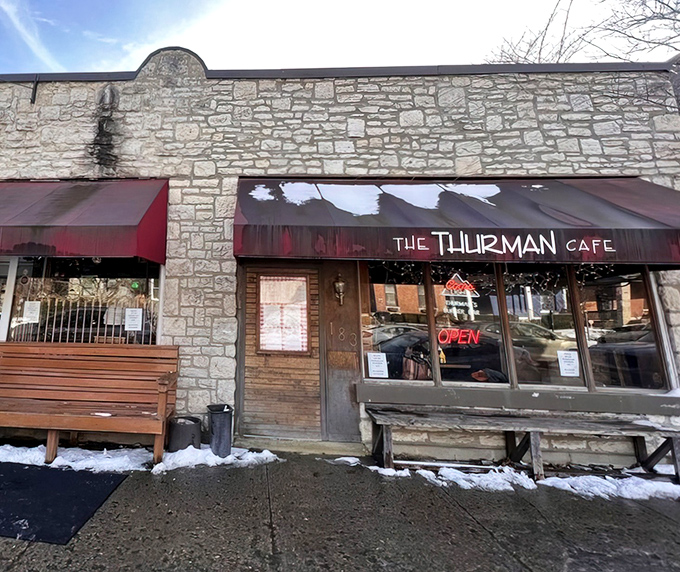 The stone facade and bright red awnings of Thurman Cafe stand like a culinary fortress in Columbus's German Village, promising burger adventures within.