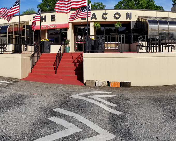The iconic cream-colored exterior of The Beacon, with its bold signage and American flags, stands as Spartanburg's culinary lighthouse guiding hungry travelers home.