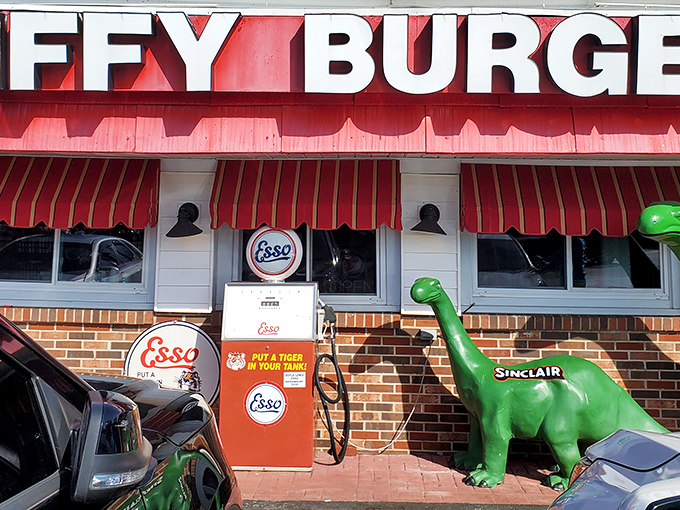 The green Sinclair dinosaur stands guard outside Jiffy Burger like a prehistoric bouncer who's really into comfort food. Red awnings and vintage gas pumps complete this time-travel tableau.