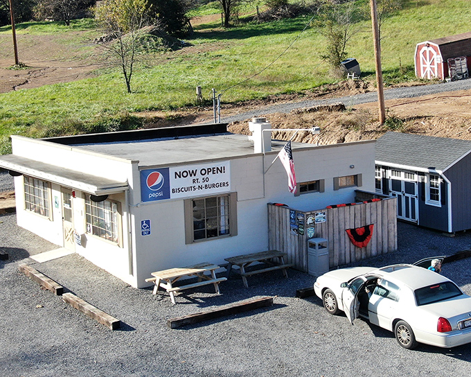 The humble exterior of Rt.50 Biscuits & Burgers glows with promise at dusk, string lights beckoning hungry travelers like a culinary lighthouse in Romney.
