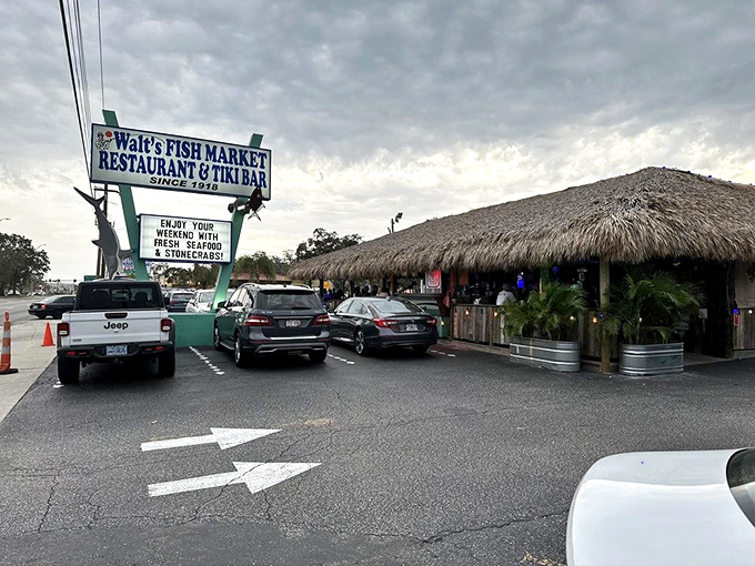 The thatched-roof paradise of Walt's Fish Market beckons like a mirage on Tamiami Trail, promising seafood treasures beneath its tropical canopy.