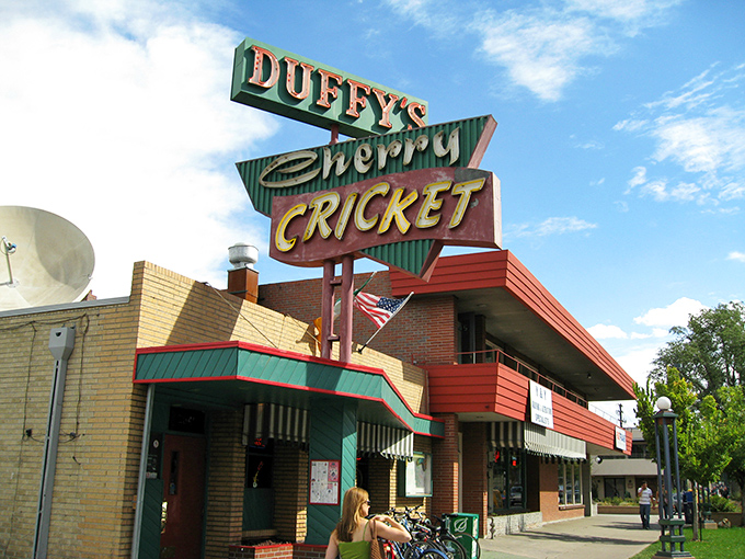The iconic Duffy's Cherry Cricket sign stands as a beacon of burger bliss in Denver's Cherry Creek neighborhood, promising unpretentious delights within those brick walls.