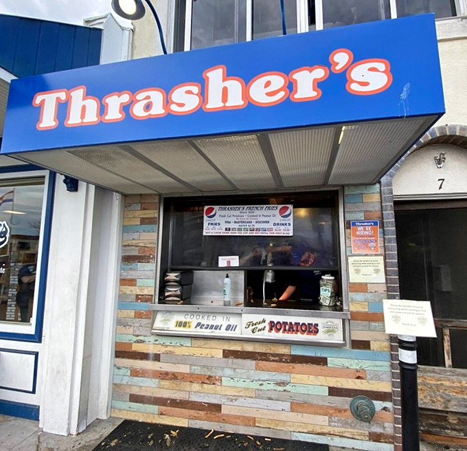 The iconic blue and orange Thrasher's sign beckons beach-goers like a potato-powered lighthouse on Rehoboth's boardwalk. Summer pilgrimage status: mandatory.