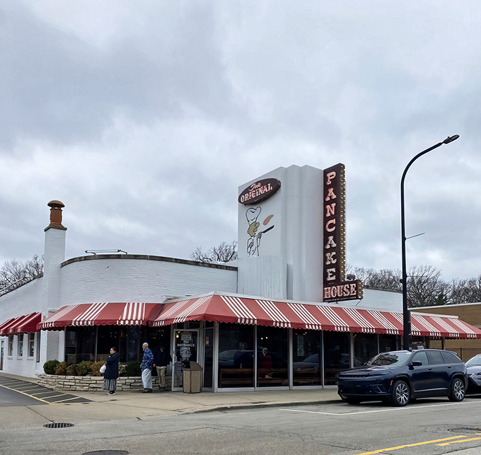 The iconic white building with red-and-white awnings stands like a breakfast beacon, calling hungry pilgrims from across Illinois to pancake paradise.