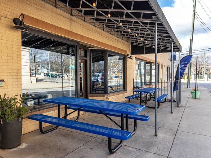 The bright blue picnic tables outside Smash'd Burger Bar are like a beacon calling to hungry travelers. No pretension here, just the promise of honest-to-goodness flavor.