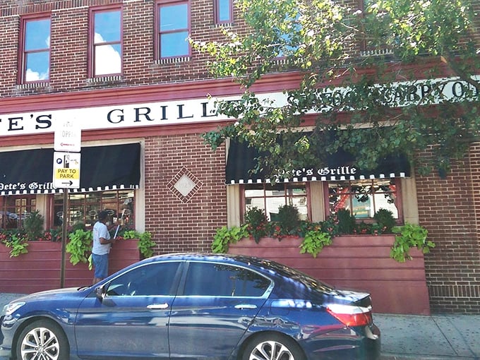 The iconic red brick corner that houses Pete's Grille stands like a beacon of breakfast hope on Greenmount Avenue, promising pancake perfection inside.