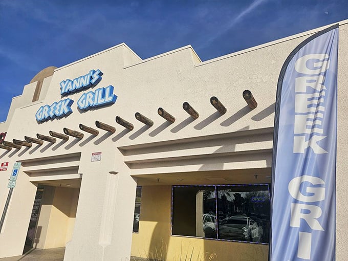 The unassuming exterior of Yanni's Greek Grill stands like a Mediterranean mirage in the Las Vegas desert, promising authentic flavors behind its blue signage.