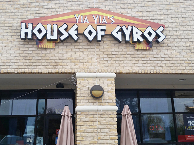 The glowing sign of Yia Yia's House of Gyros beckons like a Mediterranean lighthouse in a sea of Texas strip malls. Greek paradise awaits inside! 