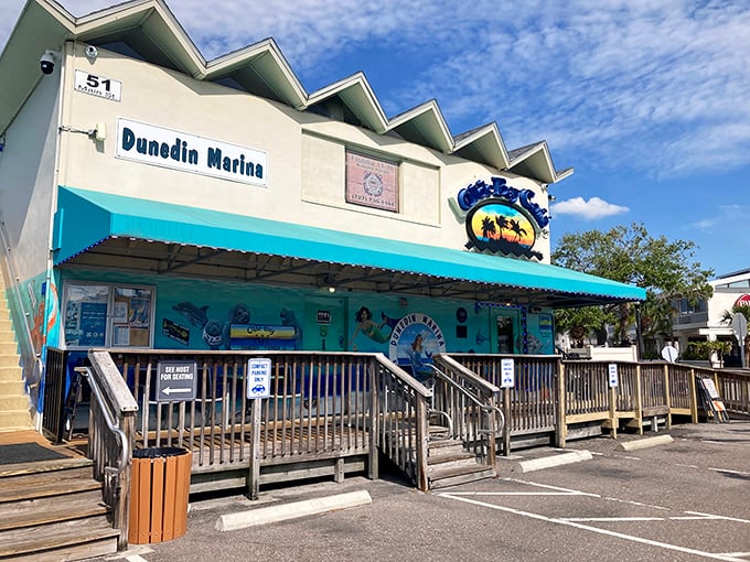 The unassuming entrance to seafood paradise. Olde Bay Caf&eacute;'s blue awning and weathered wooden deck promise authentic Florida dining without pretense.