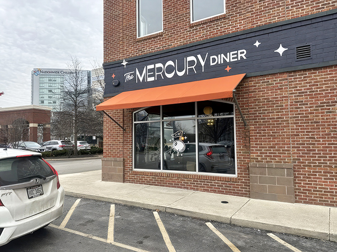 The retro-futuristic facade of The Mercury Diner makes a bold statement with its navy blue paint, orange awning, and playful star accents&mdash;cosmic comfort food awaits inside.