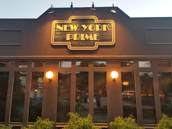 The illuminated sign of New York Prime glows like a beacon for carnivores, promising an escape from the ordinary beach fare that surrounds it.