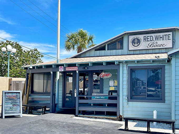 The seafoam-blue exterior of Red, White and Booze stands like a coastal sentinel, promising nautical comforts and "HAPPINESS" right above the door. Truth in advertising!