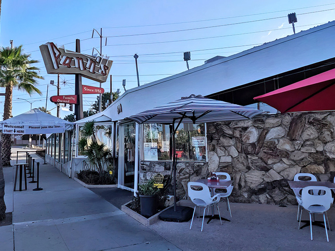 The iconic angular roof and neon sign of Pann's stands like a mid-century time machine, palm trees swaying as if to say "classic California awaits inside."