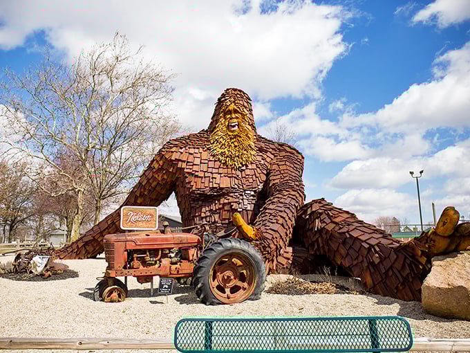 Nelson the Sasquatch lounges casually by his vintage tractor, looking like he's about to ask if you've considered switching to farm-to-table dining options.