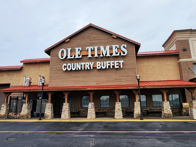 The rustic wooden facade of Ole Times Country Buffet beckons hungry travelers like a Southern siren song. Red roof, stone pillars, and all-you-can-eat promises await.