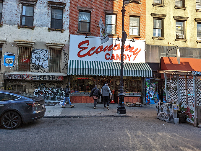 The iconic red cursive sign of Economy Candy beckons sugar-seekers like a lighthouse for sweet-toothed sailors navigating the Lower East Side.
