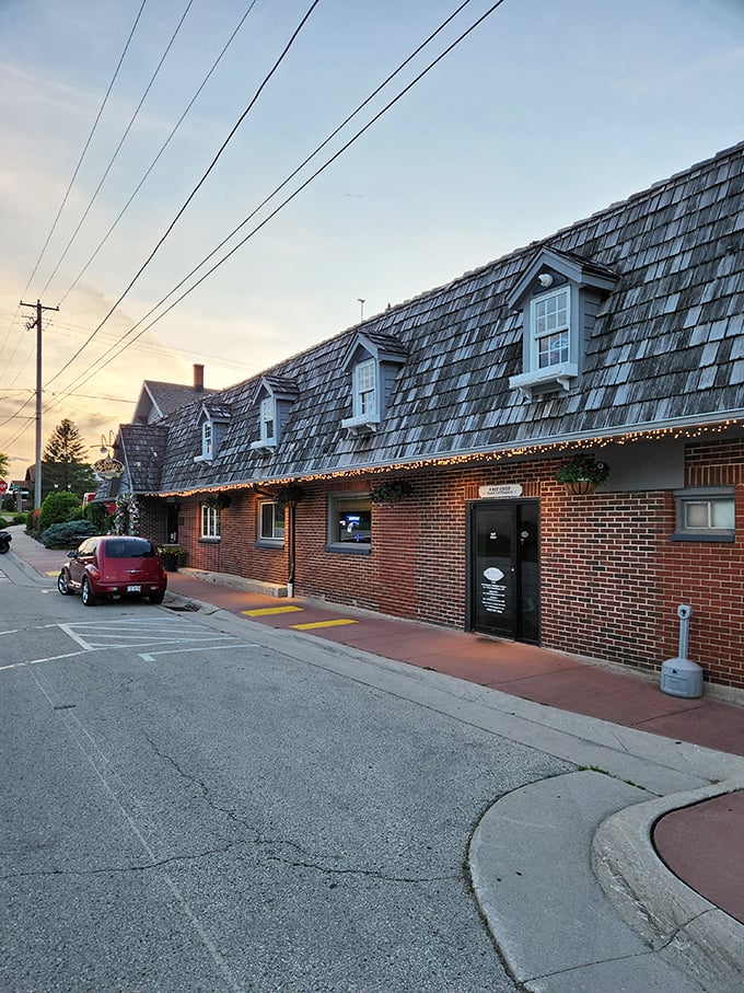 The iconic shingled roof and brick exterior of Schwarz's stands as a beacon of culinary tradition in New Holstein, welcoming hungry pilgrims at dusk.