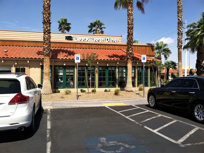 The rustic stone-and-timber facade of Black Bear Diner stands like a mountain lodge mirage in the Nevada desert, promising comfort food salvation to weary travelers.