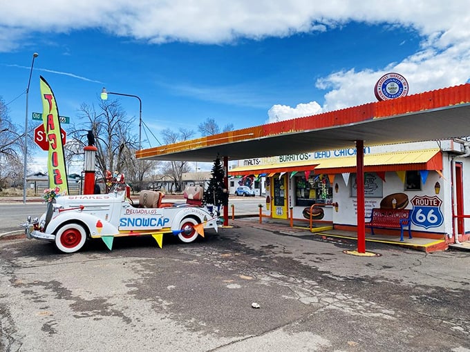 The Snow Cap's technicolor facade stands as a Route 66 landmark, complete with ice cream cone signage and colorful bunting that screams "Americana lives here!"