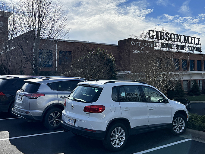 The iconic brick exterior of Gibson Mill stands proud against Carolina blue skies, a former textile factory now housing treasures waiting to be discovered. 