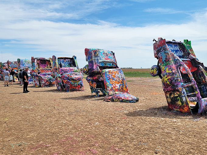 Ten Cadillacs nose-diving into the Texas dirt like synchronized swimmers who forgot the "swimming" part. American automotive history meets desert art installation.