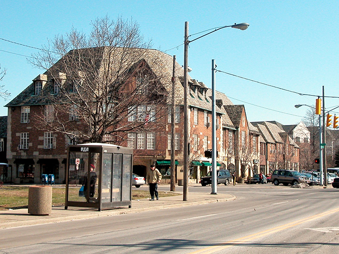 Tudor-style buildings line Cedar Fairmount district, where historic charm meets modern convenience. The bus shelter reminds you that car-free living is entirely possible here.