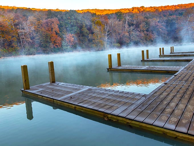 Nature's perfect postcard moment: a rustic wooden bridge leads you between cascading waterfalls, promising adventure with every step into this emerald paradise.