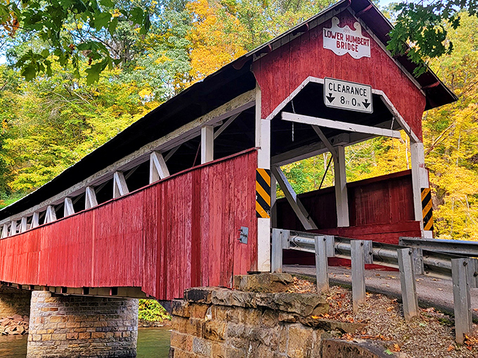 The Lower Humbert Bridge stands like a crimson sentinel against autumn's golden backdrop, a perfect postcard from Pennsylvania's storied past.