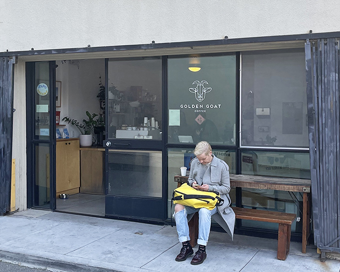 Simplicity speaks volumes at Golden Goat Coffee's unassuming entrance, where the wooden bench outside is just the first hint of the rustic charm waiting inside.