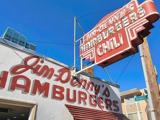 The iconic red sign beckons like a neon time machine, promising hamburgers and chili that have satisfied Sacramento appetites for generations.