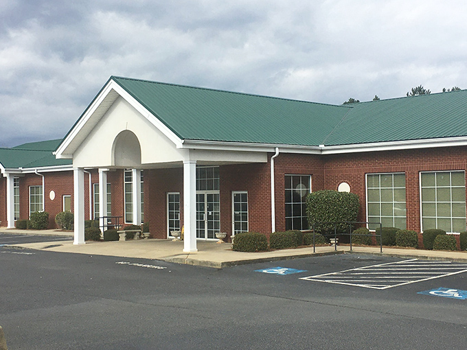 The welcoming brick exterior with its distinctive green roof promises comfort before you even step inside. Southern hospitality starts at the front door.
