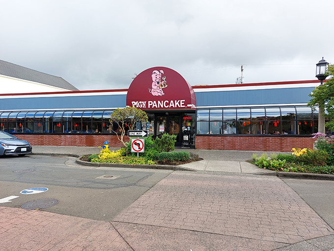 The iconic red and blue exterior of Pig 'N Pancake stands as a beacon of breakfast hope on the Oregon coast, promising comfort food salvation to hungry travelers.