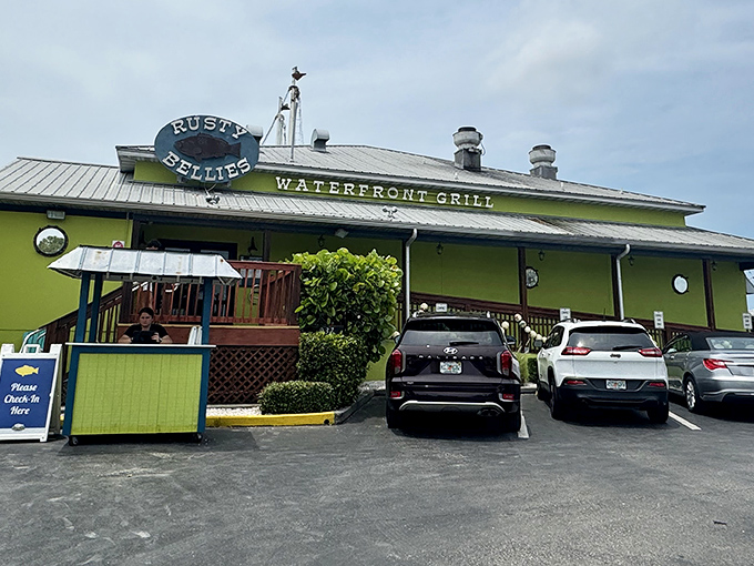 The lime-green exterior of Rusty Bellies stands out like a tropical beacon, promising seafood treasures within its cheerful waterfront walls.