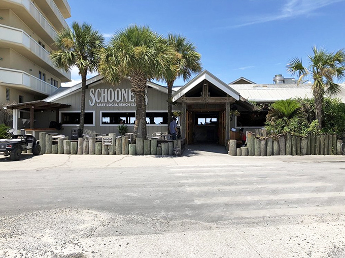 Schooners proudly declares itself "The Last Local Beach Club" &ndash; a weathered wooden oasis where palm trees and Harley parking signs set the perfect Florida mood.