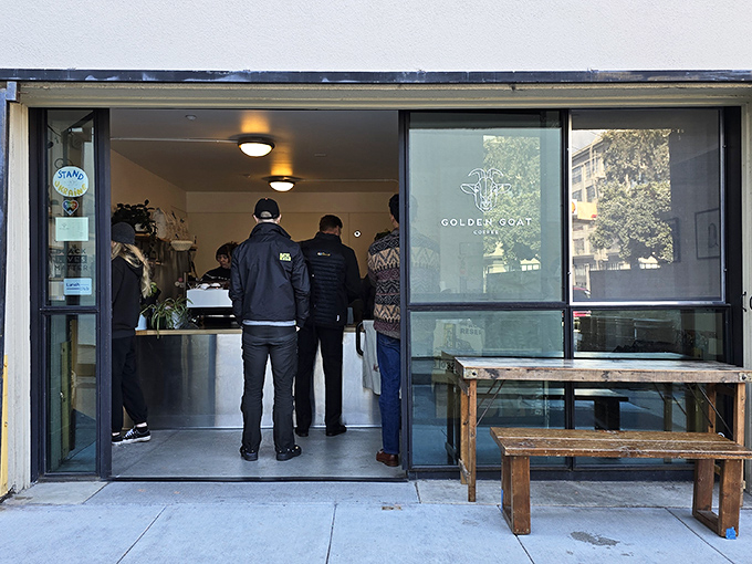 Simplicity speaks volumes at Golden Goat Coffee's unassuming entrance, where the wooden bench outside is just the first hint of the rustic charm waiting inside.