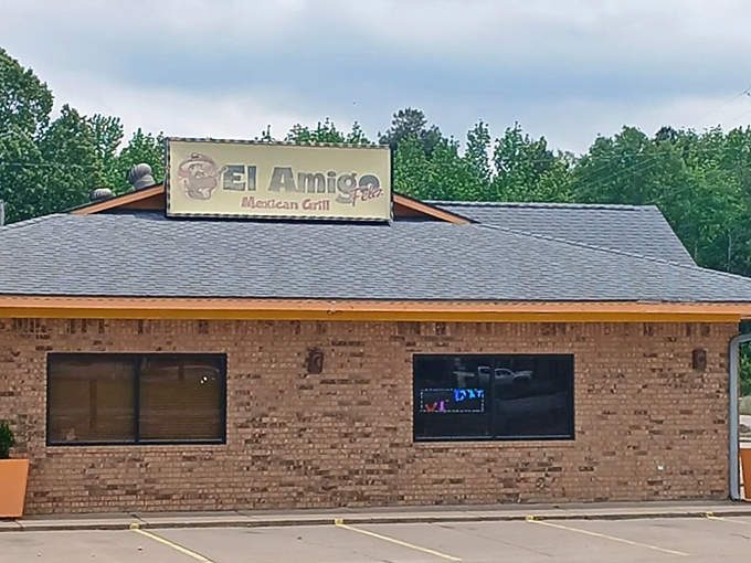 The unassuming brick exterior of El Amigo Feliz stands like a culinary oasis in Hazen, bright orange planters hinting at the vibrant flavors waiting inside.