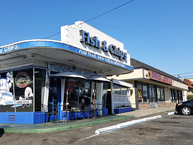 The iconic blue-trimmed exterior of Tugboat Fish & Chips stands like a maritime beacon in suburban Carmichael, promising seafood treasures within its modest walls.