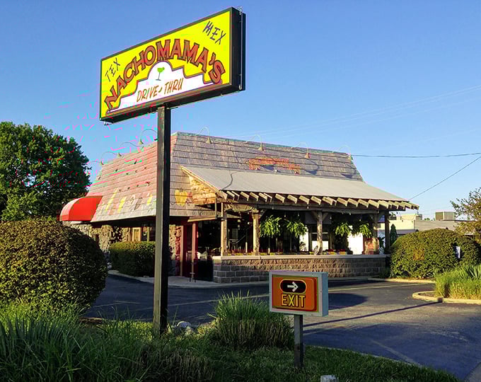 The vibrant exterior of Nachomama's beckons with colorful pepper artwork and inviting picnic tables. Tex-Mex paradise awaits behind that neon glow.