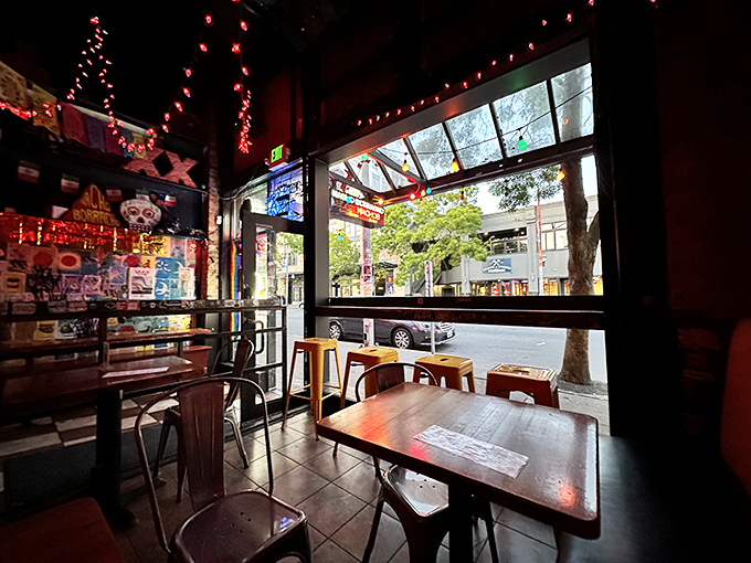 The vibrant triangular sign beckons like a neon North Star for hungry wanderers. Colorful string lights add a festive touch to Broadway's bustling scene.