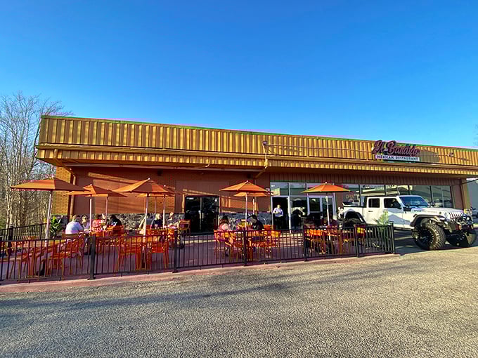 The golden glow of El Bandido's exterior promises culinary treasures within. Those red benches aren't just seating&mdash;they're the waiting room for flavor paradise.