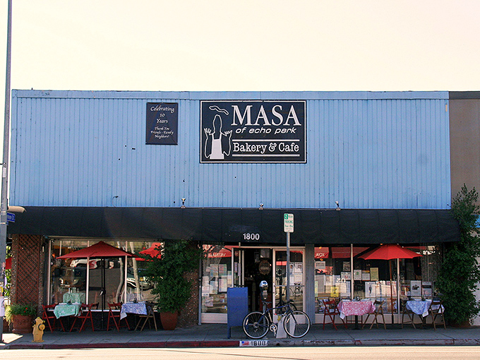 The blue exterior of Masa stands like a culinary lighthouse on Sunset Boulevard, beckoning pizza pilgrims with its no-nonsense charm and red patio umbrellas.