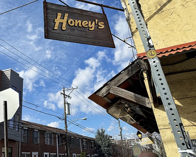 The weathered wooden sign against that sunny yellow exterior is like a beacon for breakfast pilgrims. Honey's promises comfort before you even step inside.