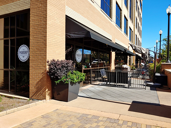 The Manship's elegant brick exterior with vibrant red hedges offers a hint of the culinary magic happening inside this Jackson gem.