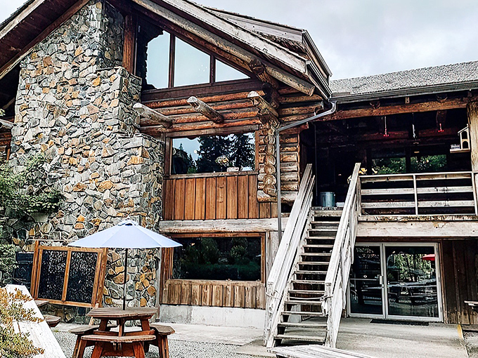 The rugged stone and timber exterior of Camp 18 stands like a mountain lodge mirage on Highway 26, beckoning hungry travelers with its impressive craftsmanship.
