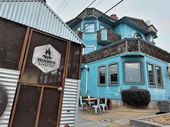 The turquoise Victorian building housing Breakwater Barbecue stands like a coastal mirage for meat lovers, where ocean breezes meet smoky perfection.