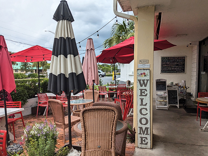 The Rooster's charming exterior with its mint-green roof and vibrant red umbrellas feels like Florida's answer to a cozy Southern porch party.