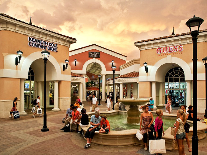 Mediterranean charm meets retail therapy under Florida skies, where shoppers gather like pilgrims at a temple of discounts
