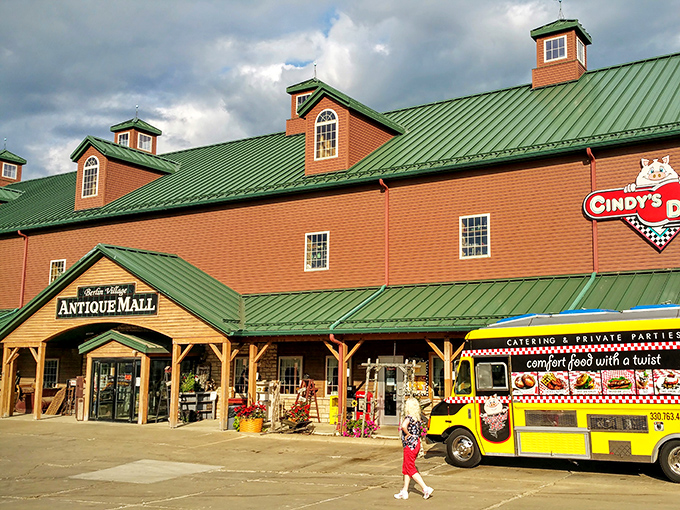 The iconic red brick and green roof of Berlin Village Antique Mall stands as a beacon for treasure hunters in the heart of Ohio's Amish Country.
