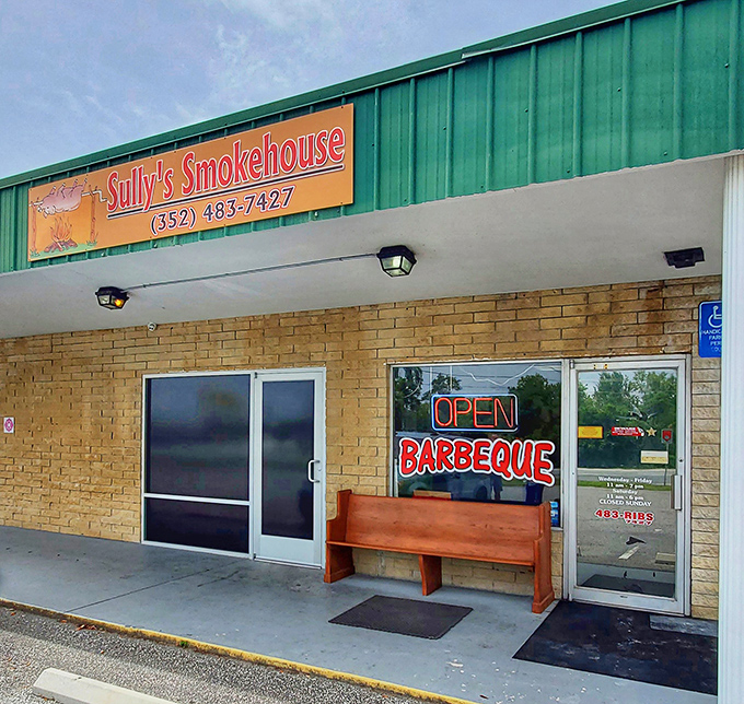 The unassuming exterior of Sully's Smokehouse proves once again that the best barbecue joints often hide behind the simplest facades. That wooden bench has heard many satisfied sighs.