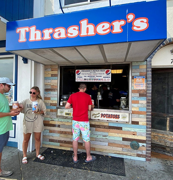 The iconic blue and orange Thrasher's sign beckons beach-goers like a potato-powered lighthouse on Rehoboth's boardwalk. Summer pilgrimage status: mandatory.